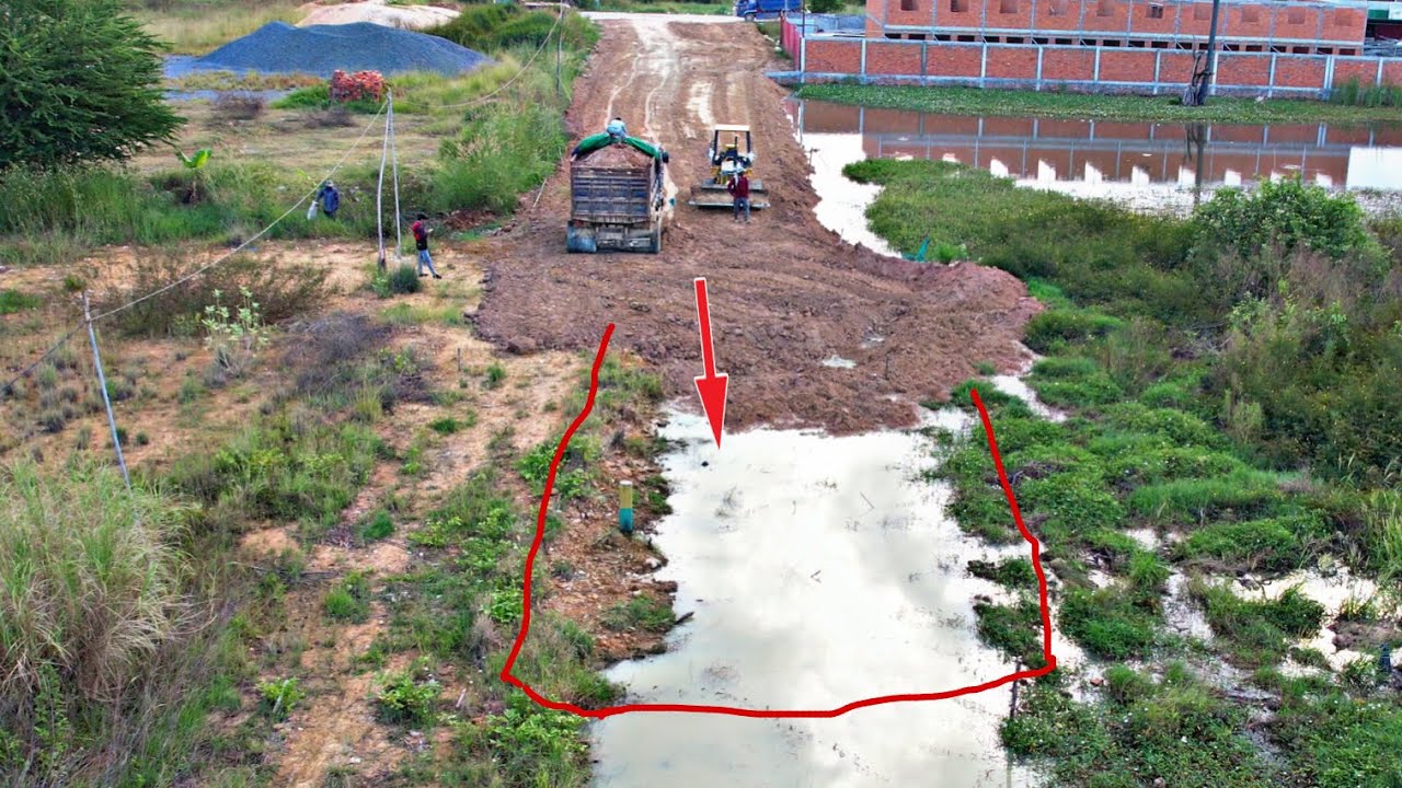 Road Construction up on water pushing by Bulldozer Komatsu D21P with ...