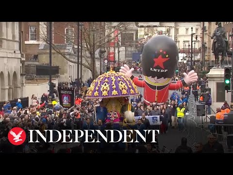 Giant inflatable Queen's guard floats through London for New Year's Day ...