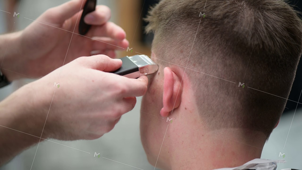 Young man's haircut in Barbershop. Close-up of master clipping hair ...