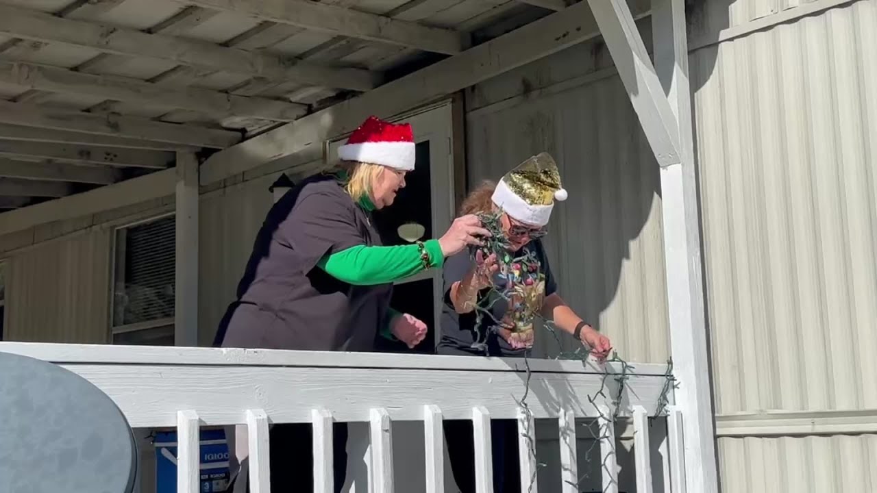 Jamie Johnson hangs lights on the front porch of Suzanne Baber's ...