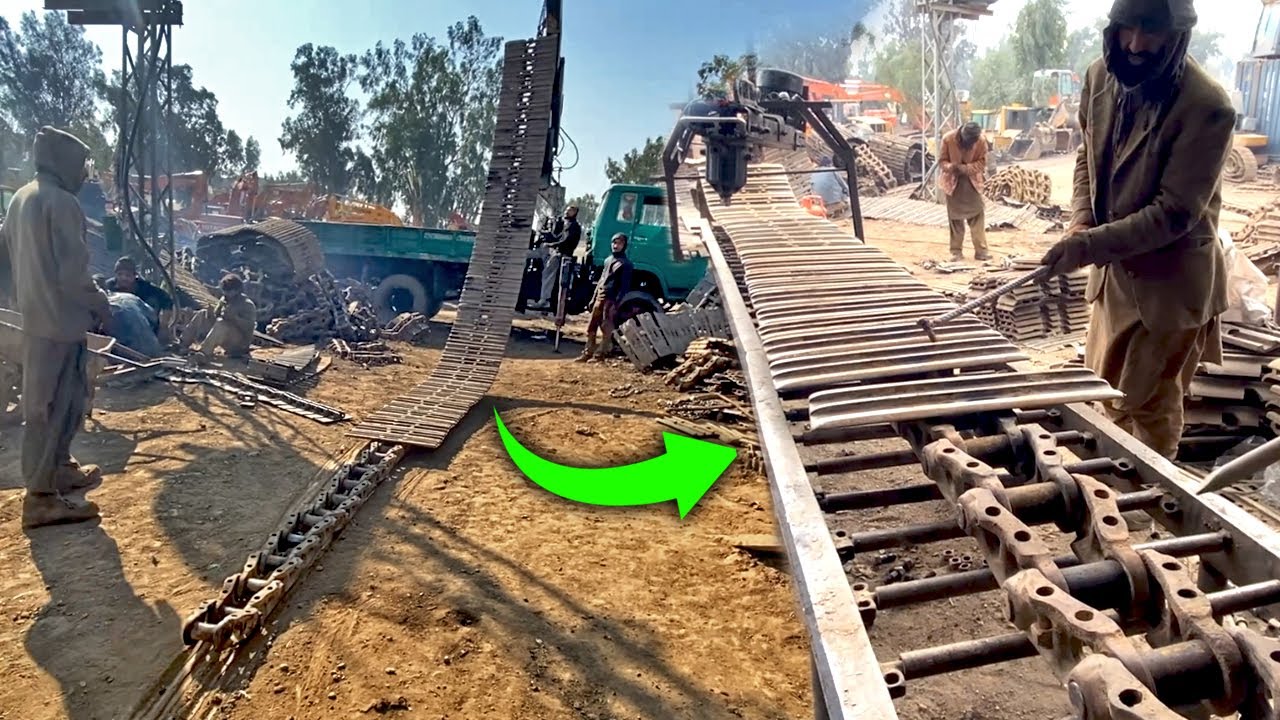 Hard-working mechanics repair the Hyundai Excavator track chain in a ...