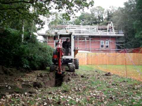 Mini excavator digging out a trench. - YouTube