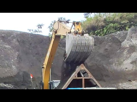 excavator works dredging sand and loading it into a dump truck - 4k ...