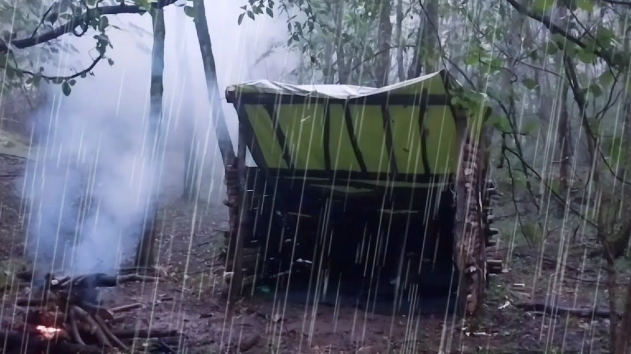 Solo camping and building a wooden hut in heavy rain, in a shelter ...