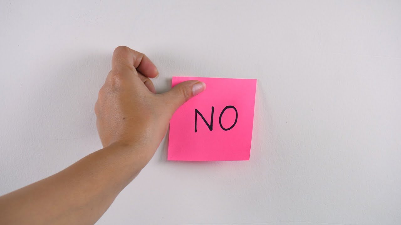 Closeup shot of woman's hand sticking note with "NO" word on a ...