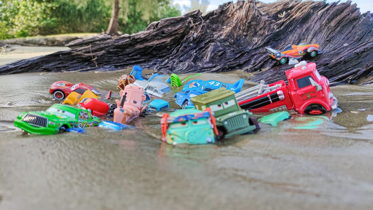 Disney Pixar Cars buried in the sand on the beach:Lightning McQueen ...