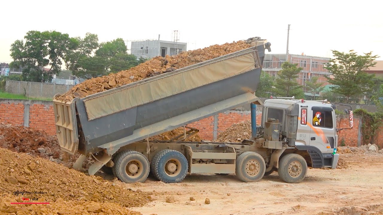 Power machine equipment dumper truck spreading dirt collaborate with ...