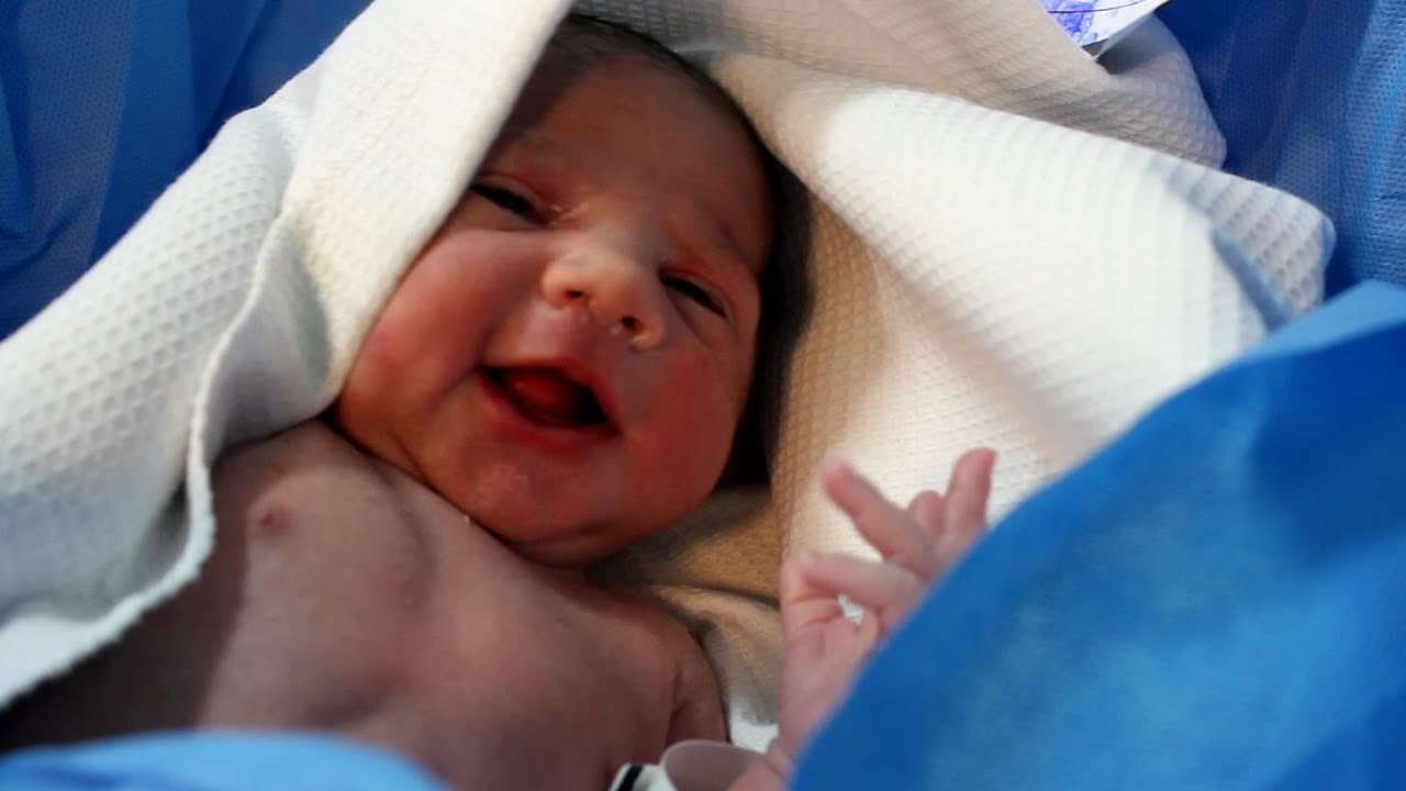 Cute newborn baby girl has started to play and be happy a few seconds ...