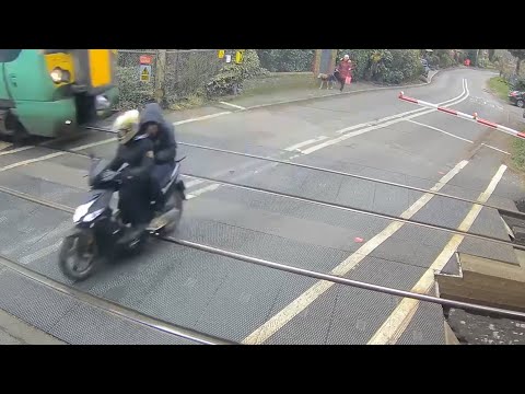 Moped riders nearly struck by train after running red light in England