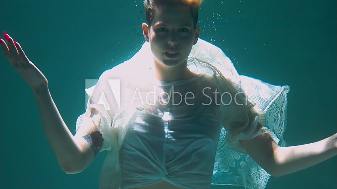 Young beautiful sad woman slowly sinking helplessly under blue water slow motion. - YouTube