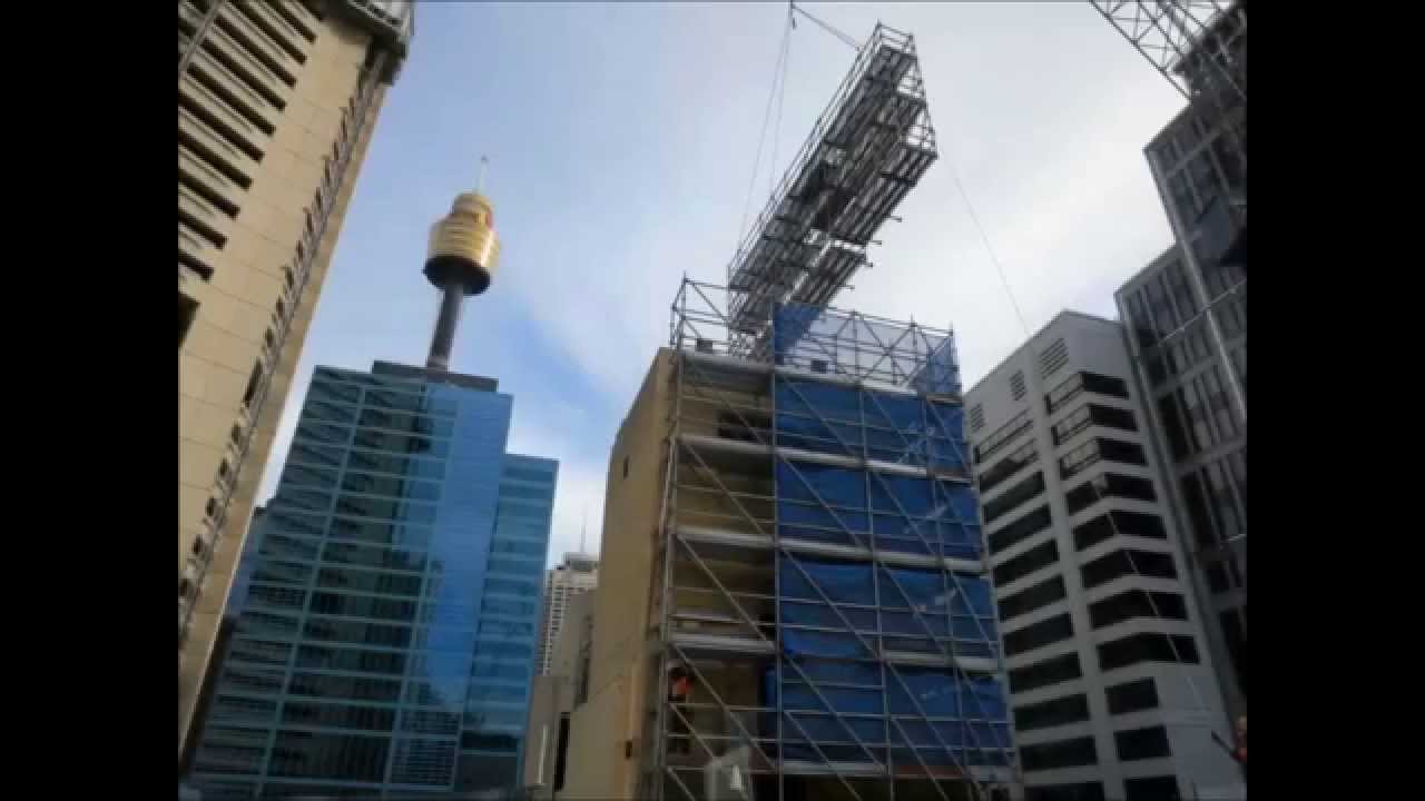 Crane install of cantilevered bridging perimeter scaffold for ...