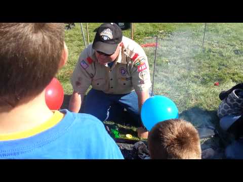 Scouts building a fire to break balloon.