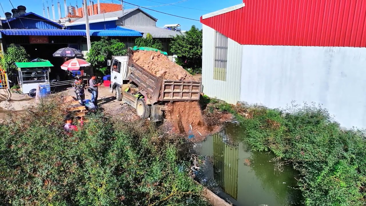 Good Project! truck dumped soil into dirty water in a garbage-filled ...