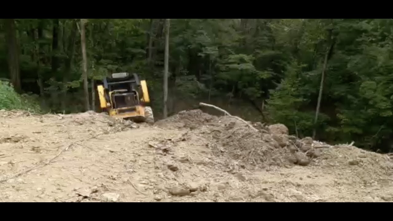 Pulling skid steer up a cliff - YouTube