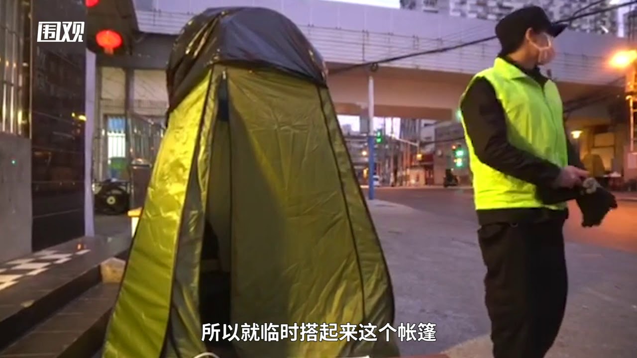Security guard sits outside old residential community with tent and ...