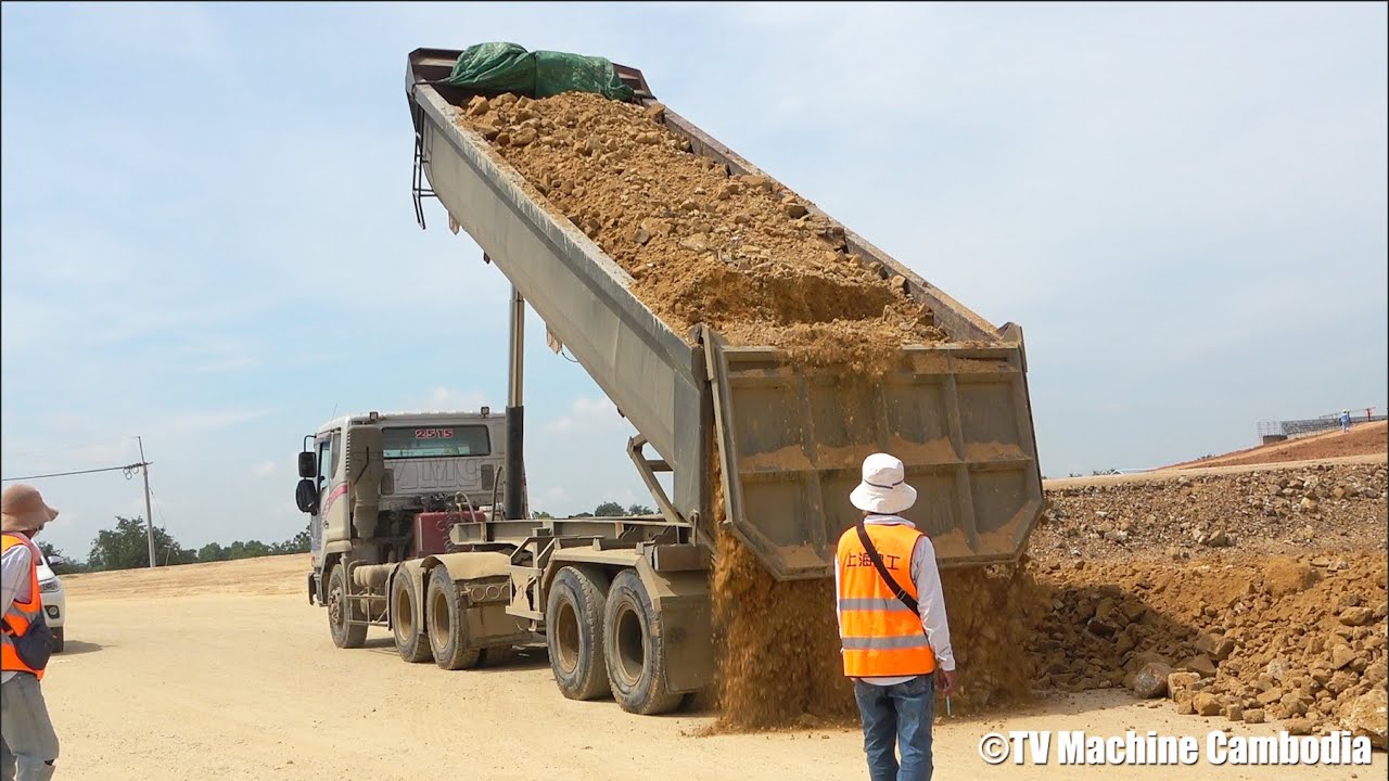 Dumping a load of dirt with dump truck trailer | truck spreading gravel ...