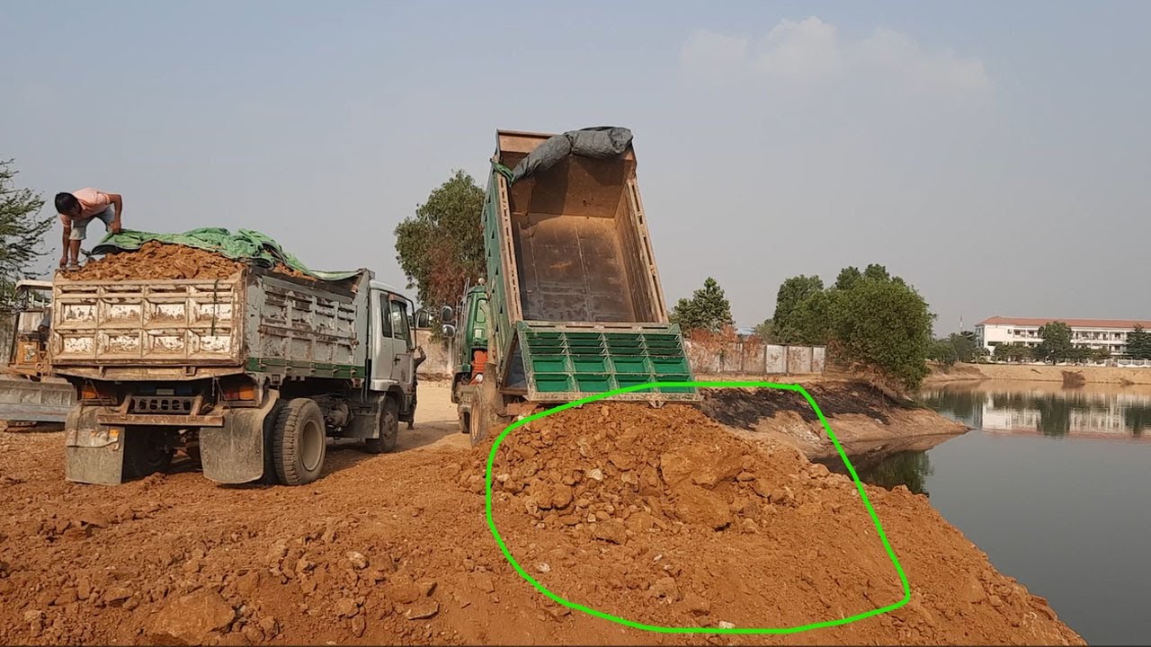 Land Filling Process Behind The Factory Dump Truck Unloading Stone Land ...