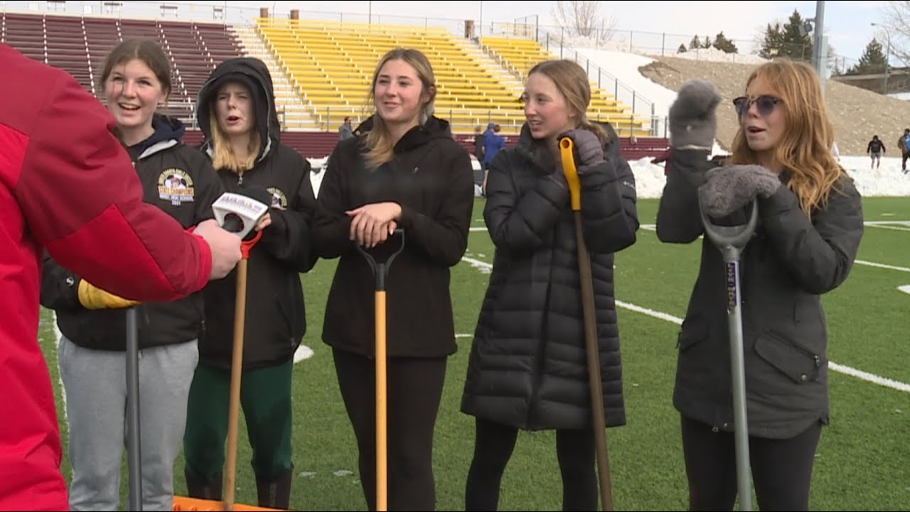 Minot community teams up to clear snow off Duane Carlson Stadium - YouTube