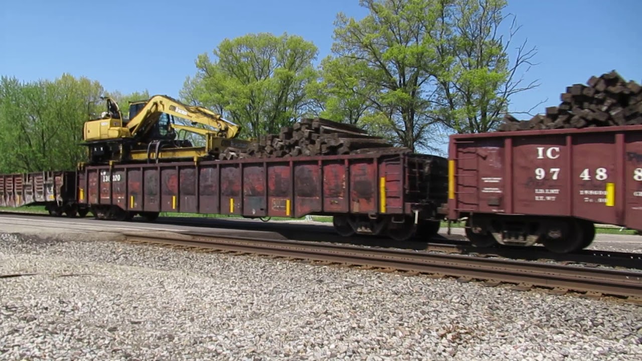 Gondolas of old railroad ties pushed East by a CN Brandt Hi-Rail Truck ...