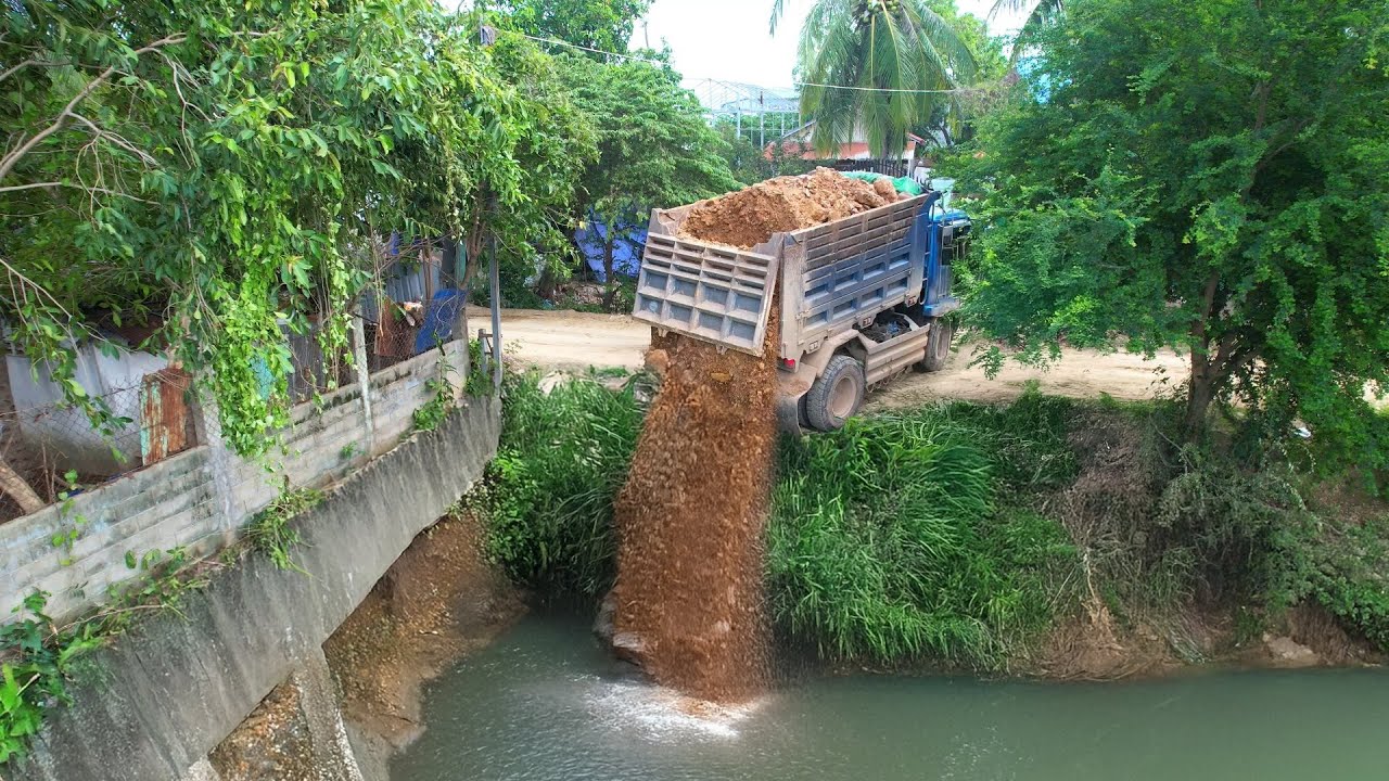 Dump Truck Unloading Thousands of Pounds of Earth into deep pit ...