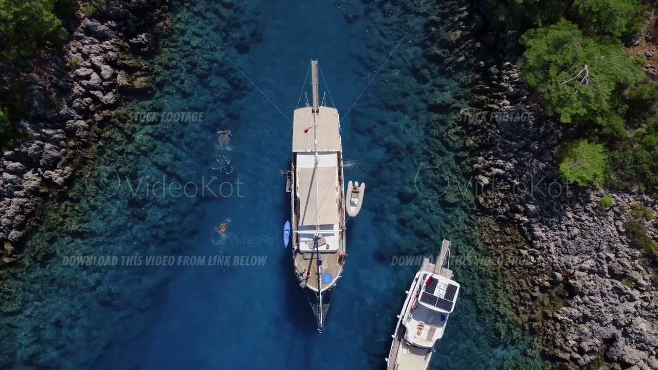 Large boat is moored in the sea strait with reef bottom and tourists ...