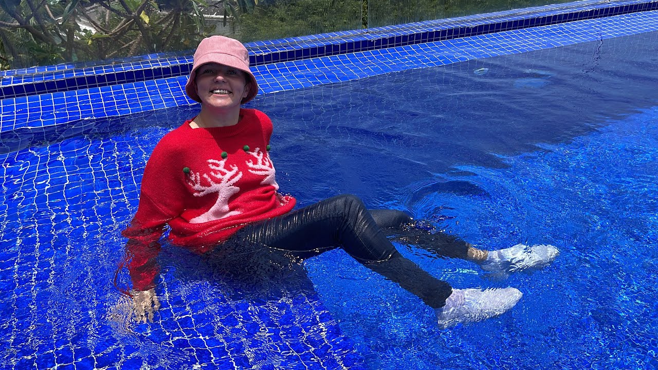 Red Christmas sweater, jeans, sneakers. Funny wetlook video in the pool ...