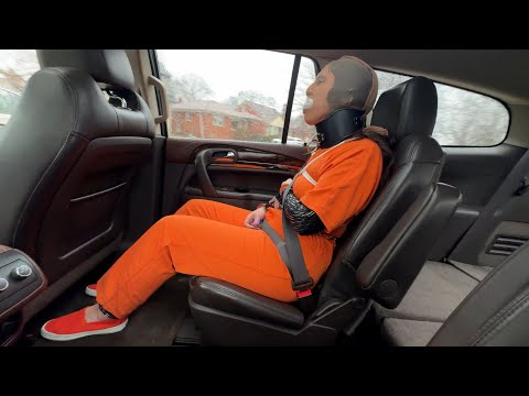 A jumpsuit, posture collar, handcuffs, stocking cap, seat belted car ride for Marie