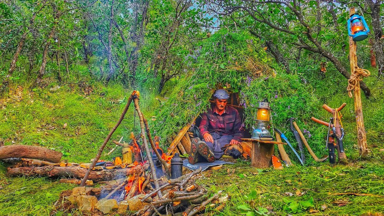 Building of a round bushcraft dugout for survival in the wild forest ...