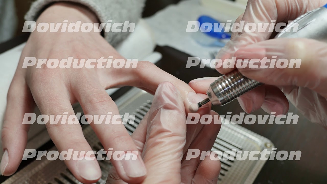 Grinding of a cuticle and side rollers. Woman's hands at manicure ...