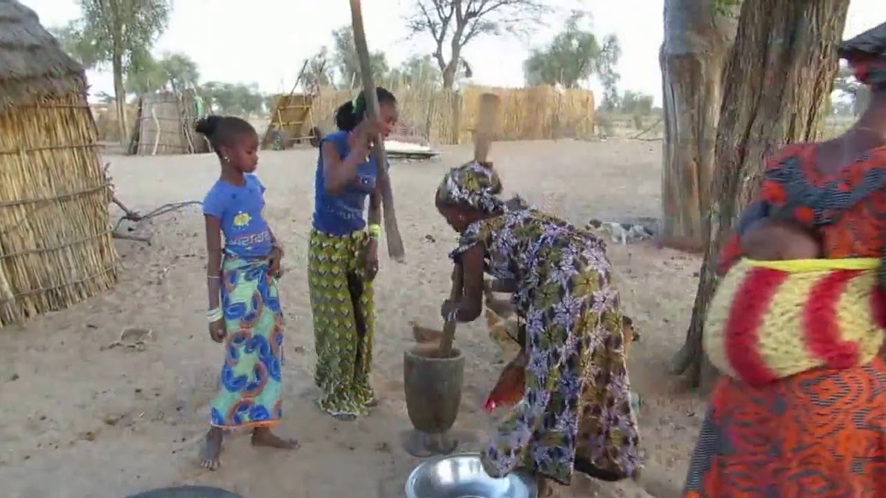 Pounding peanuts near Touba Senegal - YouTube