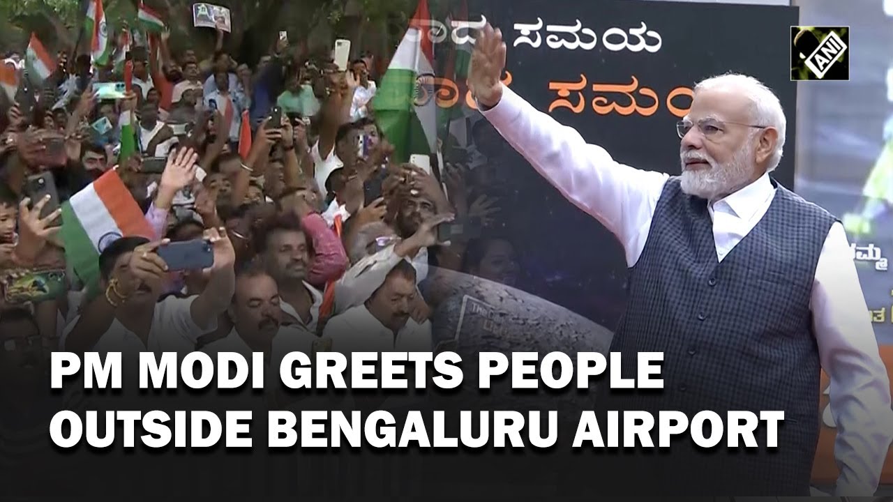 PM Narendra Modi greets people gathered outside HAL Airport in ...