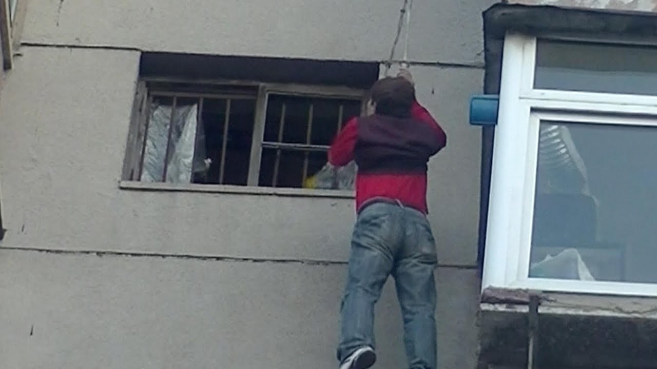 Firefighters rescue man dangling from top of building in northeast ...