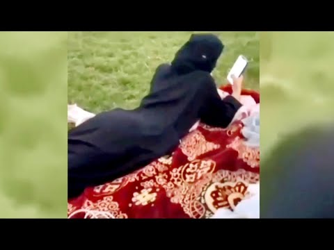 Arab girl lying on the grass with her legs raised