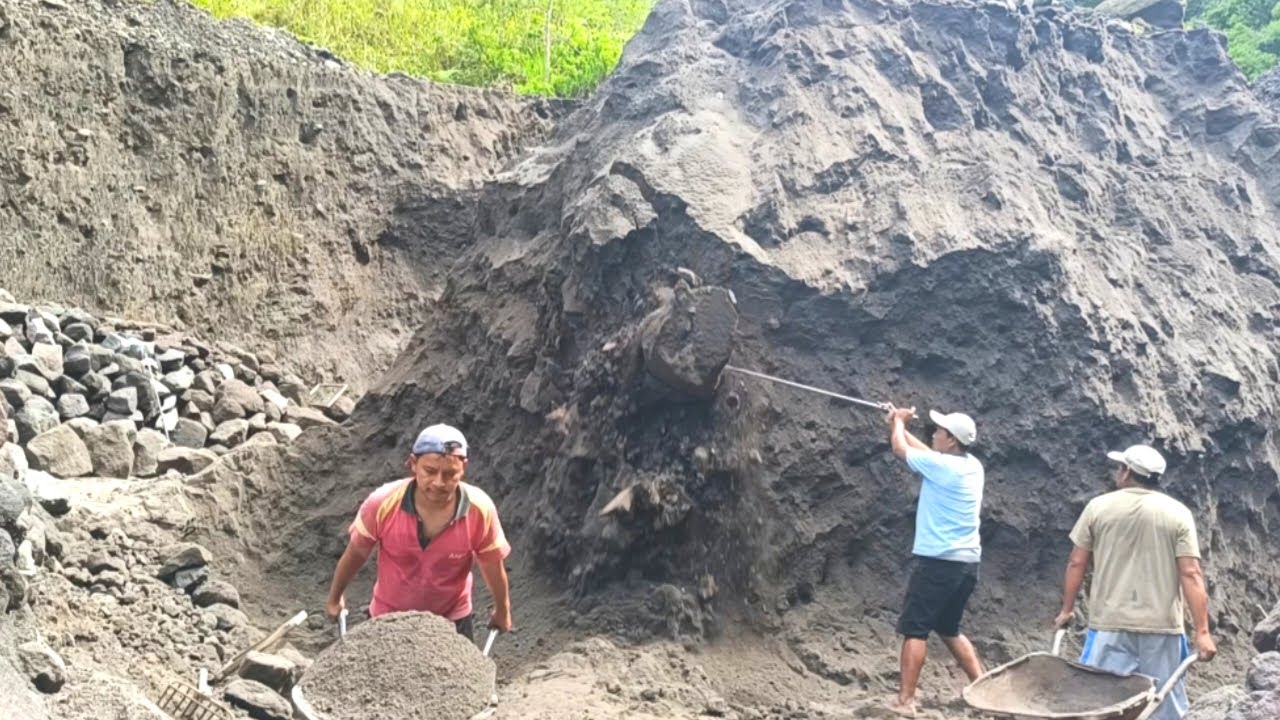 A miner knocks out something hidden in the middle of a lump of sand ...