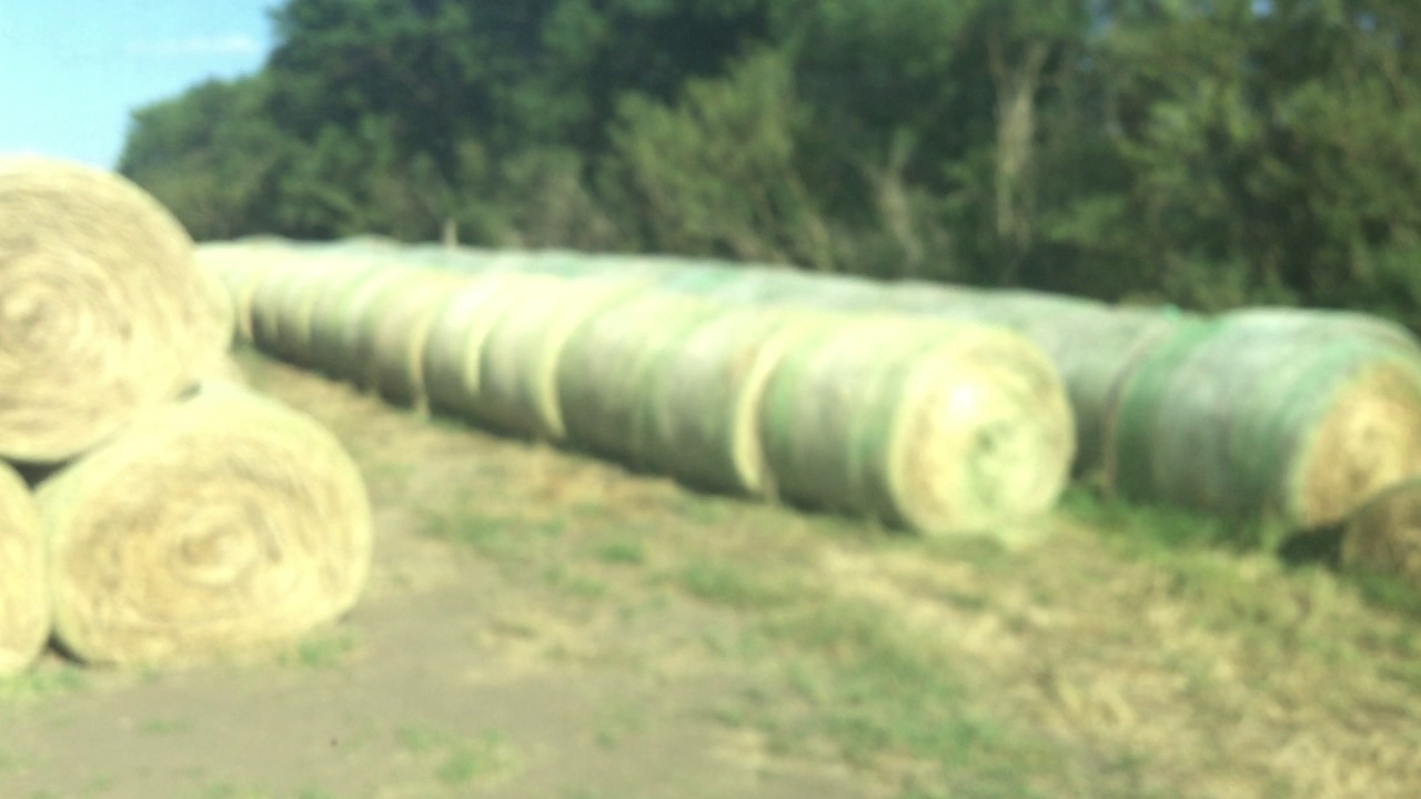 Grabbing a round bale with the 6410 JD - YouTube