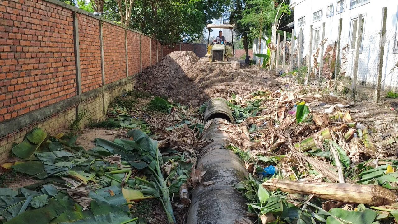 Good skills bulldozer clearing garbage and delete sewer drainage system ...