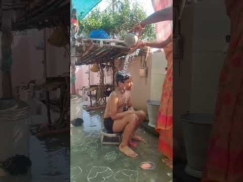 Grandmother gives her grandson a head bath