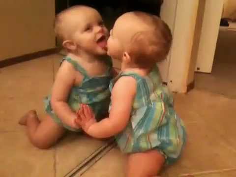 Her first kiss, cute, funny baby girl kissing in the mirror