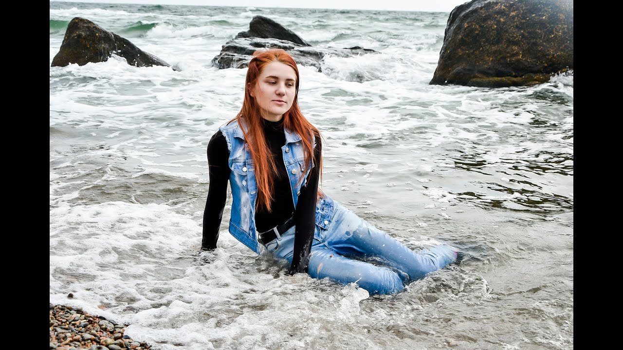 cute girl in wet denim jacket and wet jeans poses tenderly on the ...