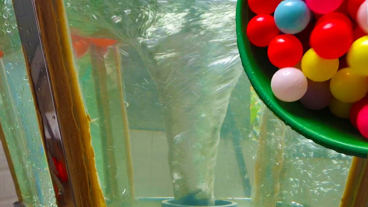 Experiment whirlpool with 100 multicolored balls with transparent glass ...