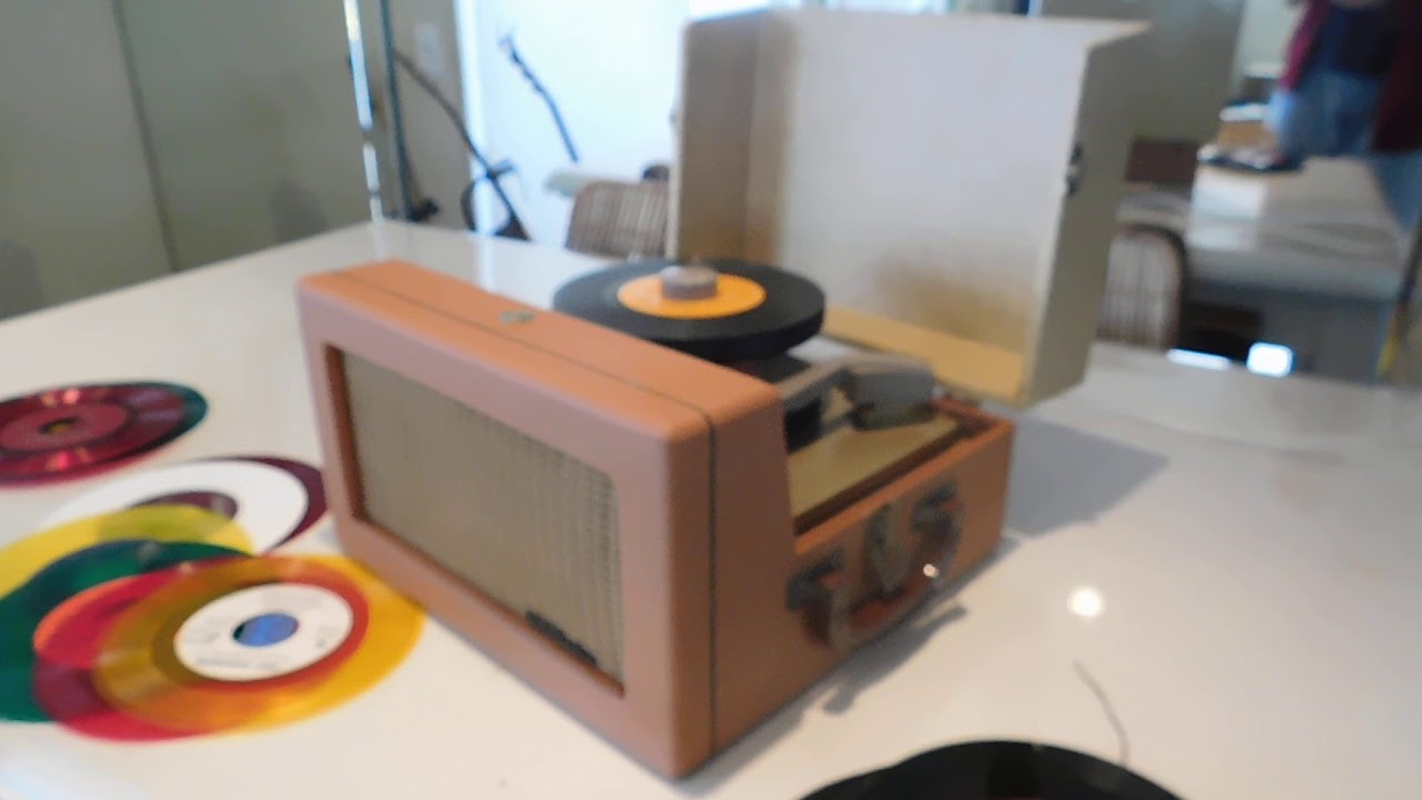 RCA 45 rpm portable record player playing a stack of 45 RPM records ...