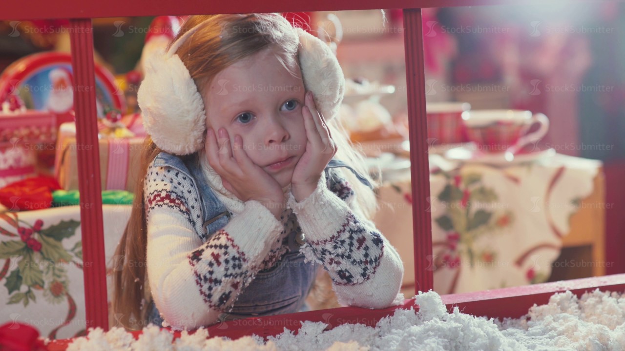 A child waiting for Christmas and Santa Claus looking out the window ...