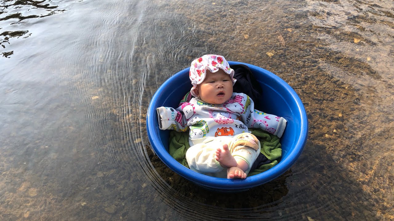A newborn baby girl must follow her mother to catch snails and crabs ...