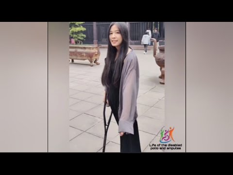 The beautiful amputee woman walks on one crutch and an artificial leg # ...