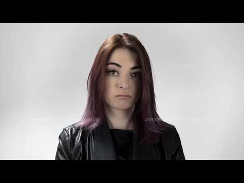 Portrait of young woman with coloured hair sadly watching in the camera and down