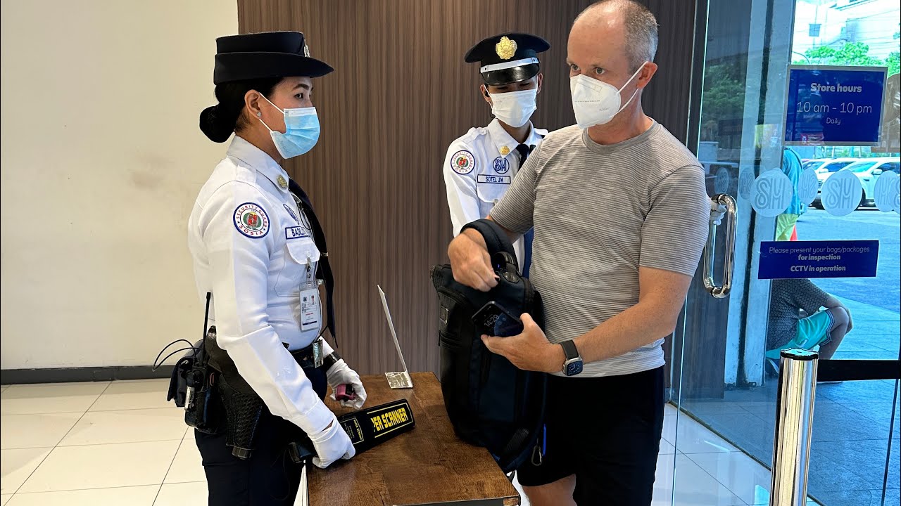Typical Manila scene. Guards with Guns. Checking bags. Standing outside ...