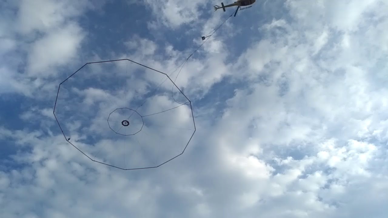 Low flying Helicopter hanging a very large loop net for ground water ...
