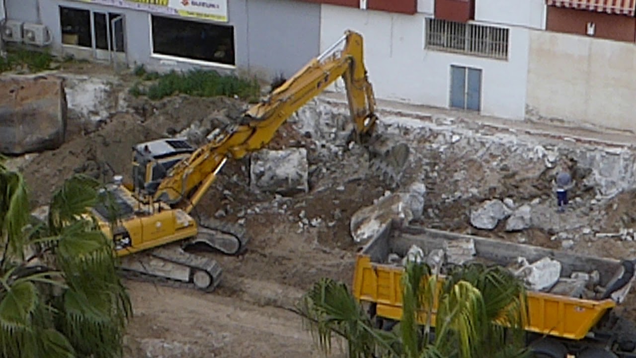 Digger moving huge slabs of concrete - YouTube