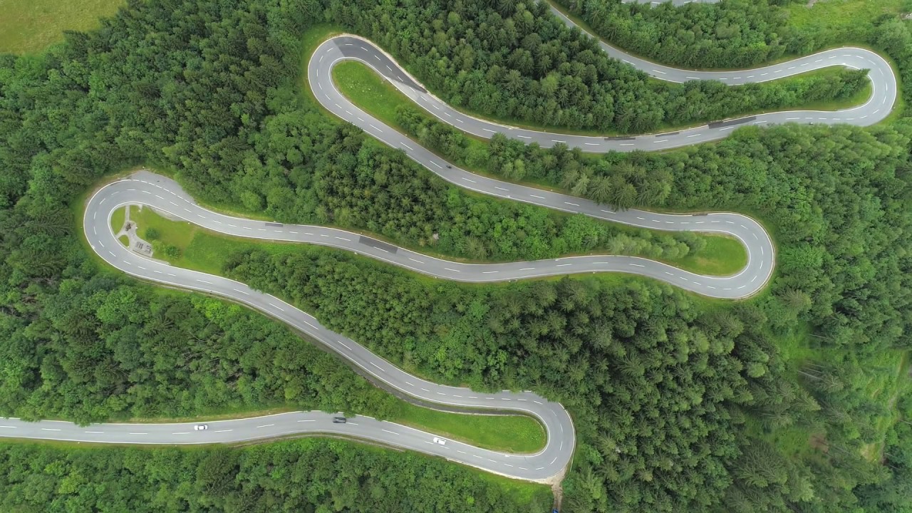 Aerial cars driving on mountain along scenic switchback road with ...