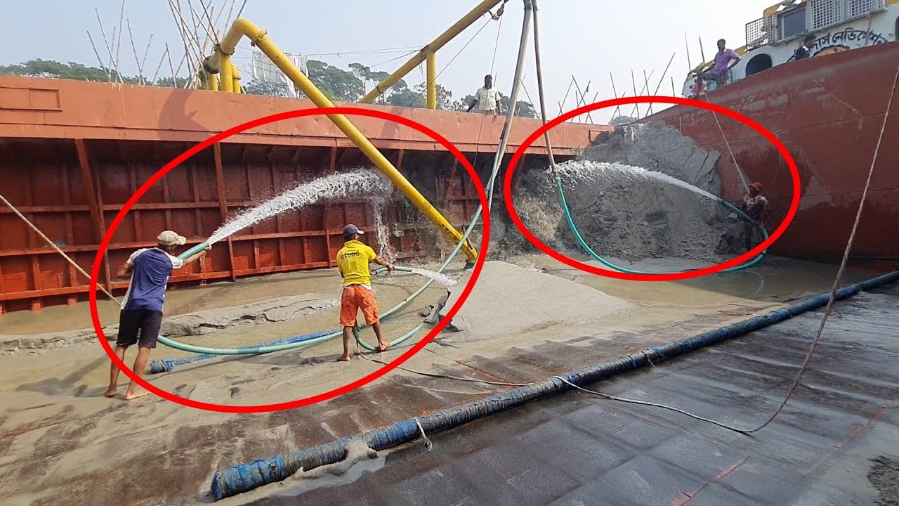 Sand is being unloaded from large ships with powerful dredger machines ...